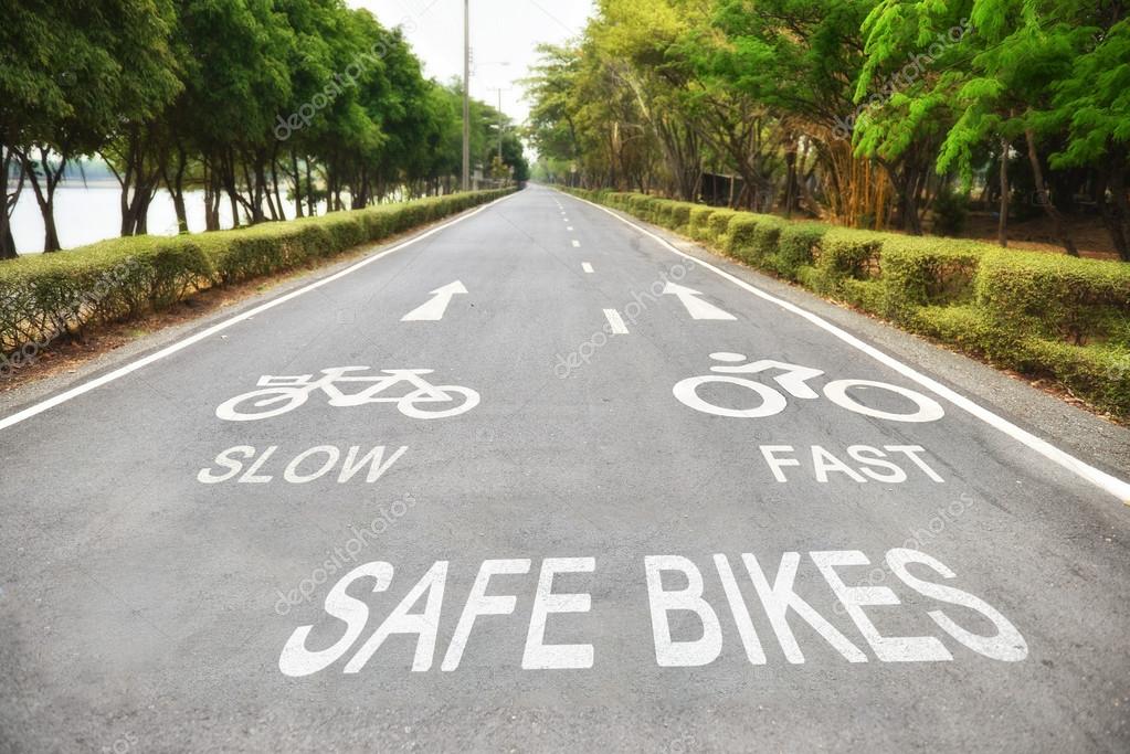 Safe bikes, slow and fast words with white arrow sign marking on road ...