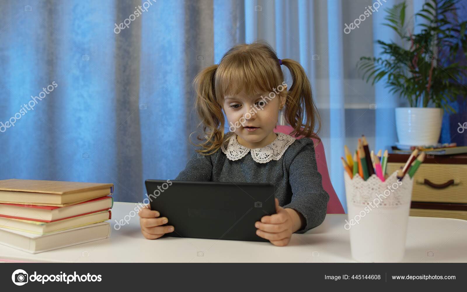 Cute kid pupil watching video lesson, studying using digital tablet ...