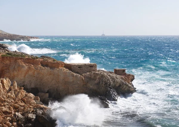 Maltese coastline with rock and stormy sea, big storm in golden sunset ...