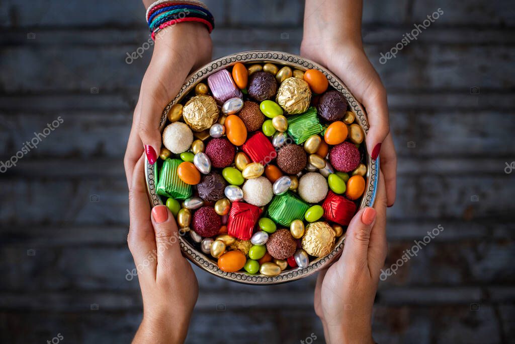 Cuenco de caramelos y chocolate a manos de dos mujeres. ikram bayrami Seker. Muchas golosinas ...