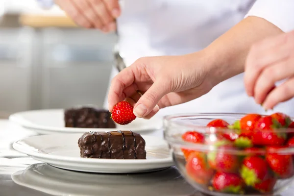 Chefs decorates dessert cake with chocolate sauce in kitchen - Stock ...