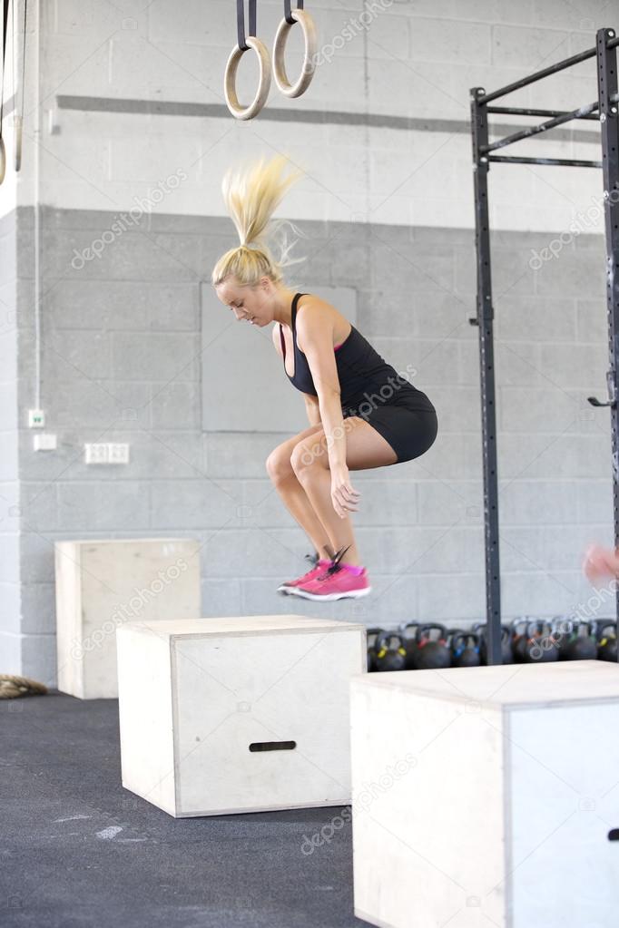 Fit young woman box jumping at the fitness gym Stock Photo by ©kjekol ...