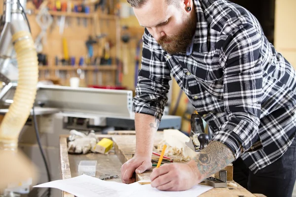 Carpenter plans work and take notes at project drawing - Stock Image ...