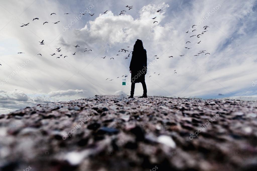 Woman standing on the rocks watching sea sunset ,dramatic view,woman on ...