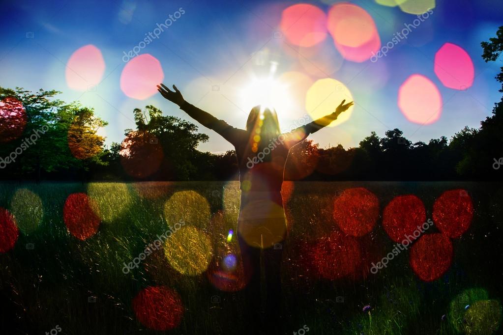 Young girl spreading hands with joy and inspiration facing the sun,sun ...