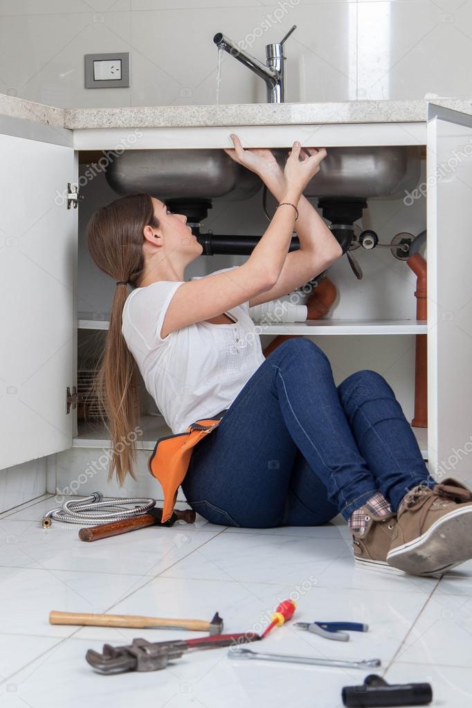 Female plumber fixing a sink Stock Photo by ©Implementar 86708770