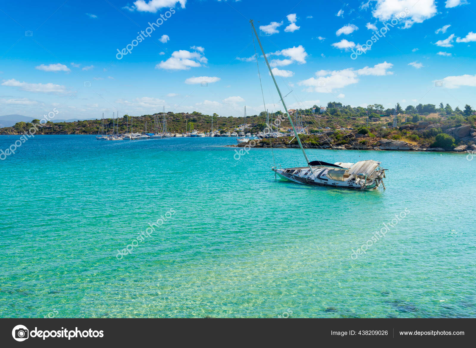 Overturned shipwrecked sunken sail boat yacht with seaweed growing on ...