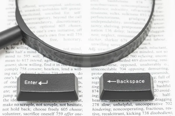 Enter and Backspace Computer Keys and a Lens on a Book Page Stock Photo ...