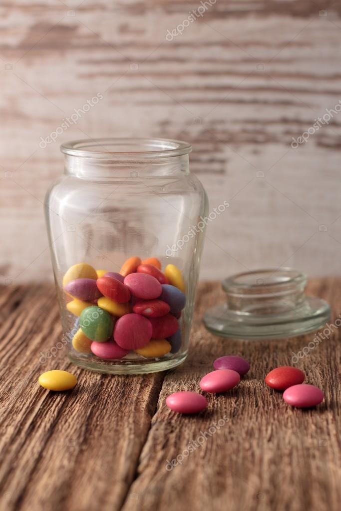 Glass jar with smarties on a wooden board — Stock Photo © yommy8008 ...