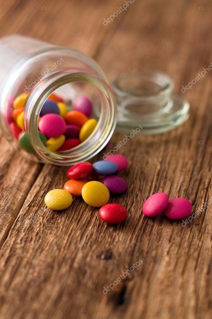 Spilled chocolate smarties around glass jar — Stock Photo © yommy8008 ...