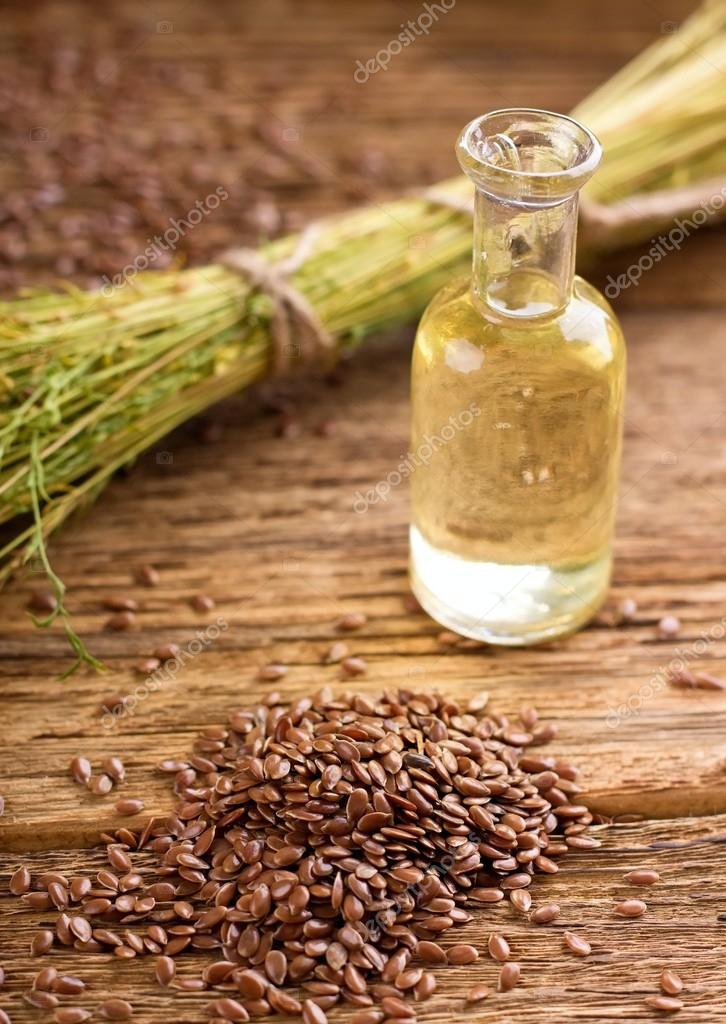 Pile of flax seeds in front of bowl with flaxoil Stock Photo by ...