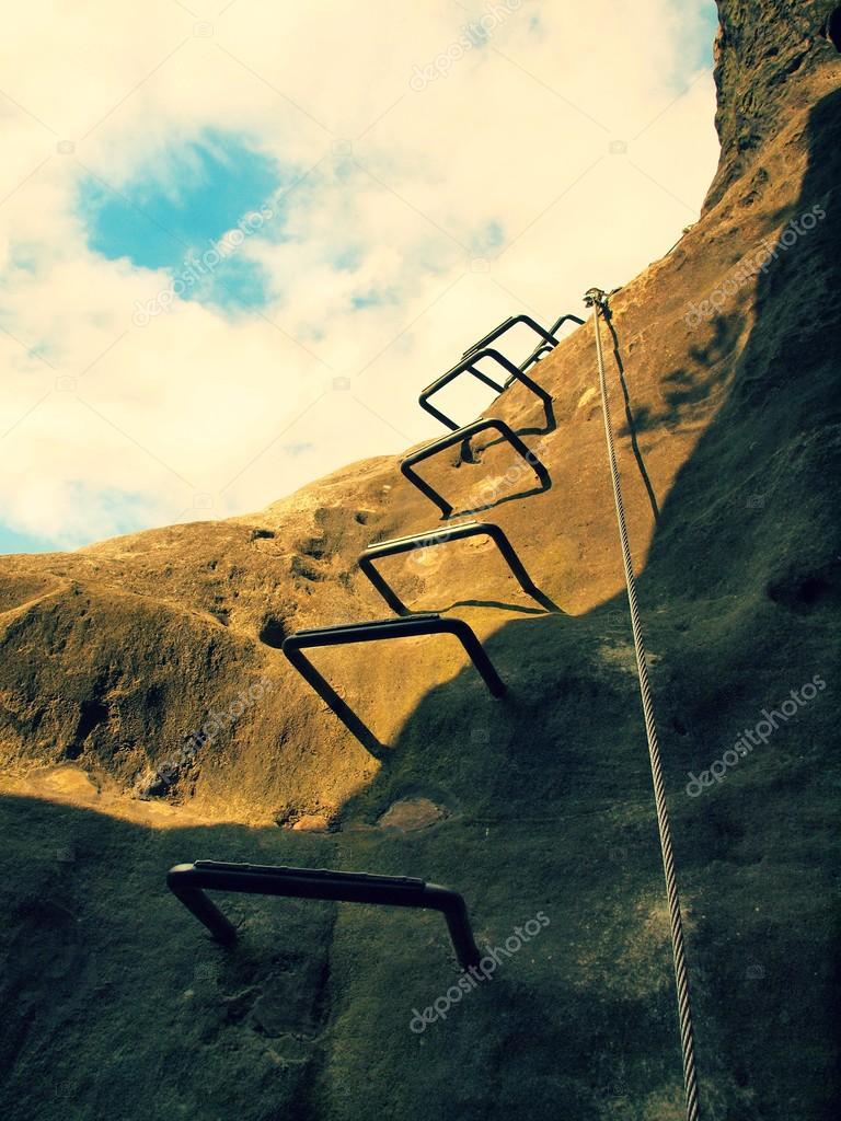 Climbers way. Iron twisted rope fixed in block by screws snap hooks ...