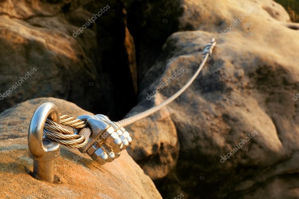 Iron twisted rope streched between rocks in climbers patch. Rope fixed ...