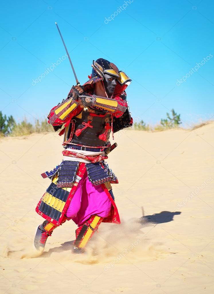 Hombre con traje de samurai con espada corriendo sobre la arena. 2024
