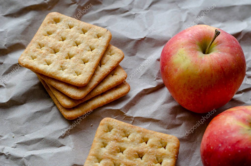 Manzanas rojas maduras y galletas cuadradas tumbadas sobre papel de ...