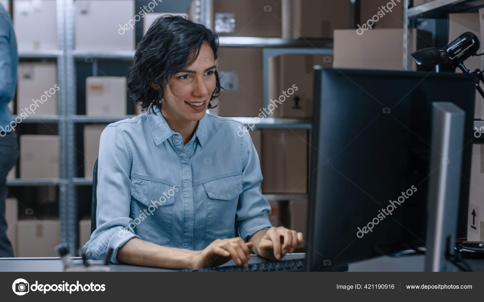 Warehouse Female Inventory Manager Works on a Computer while Sitting at ...