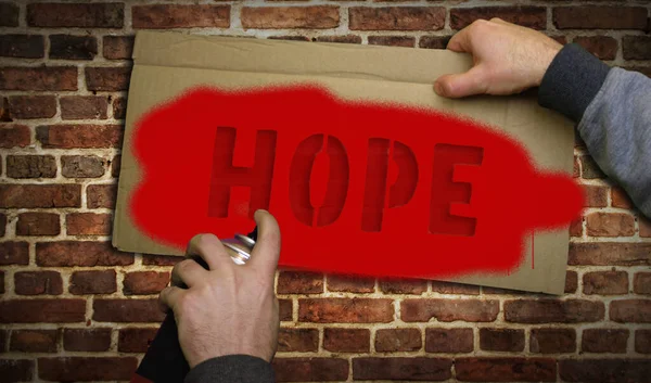 Hope spray painted red inscription on the brick wall. Graffiti art ...