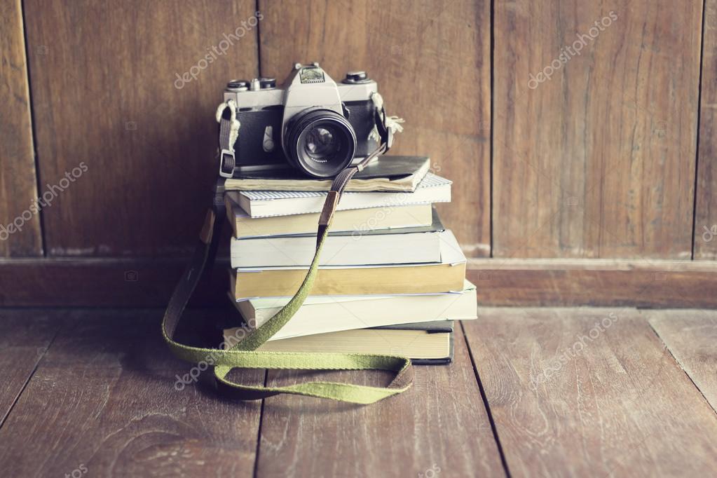 Old style camera on pile of books on wooden floor Stock Photo by ...