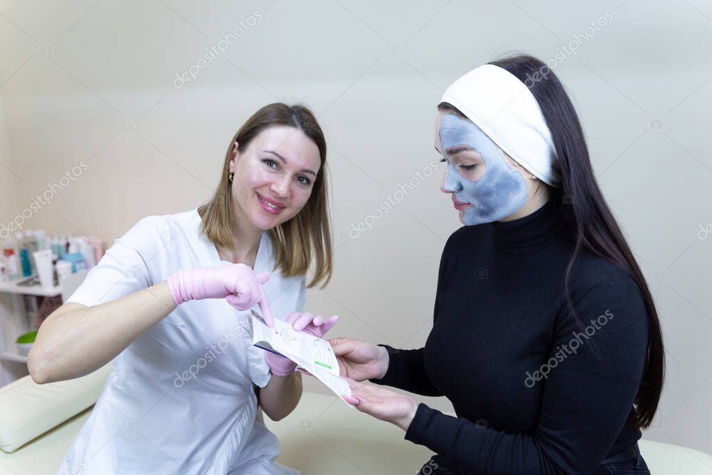 El esteticista con un abrigo blanco sonríe al cliente. Feliz ...