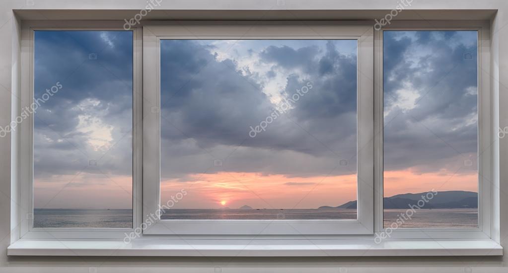 A window with the panoramic views of the sea and the beautiful sunrise ...