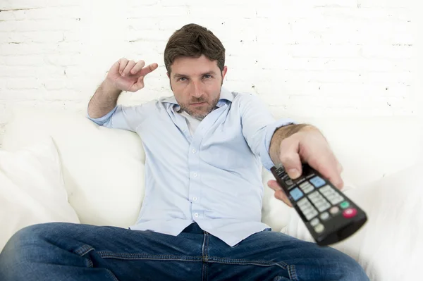 young happy man watching tv sitting at home living room sofa looking ...