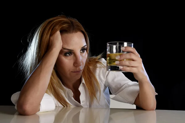Drunk alcoholic woman alone in wasted depressed face holding and looking thoughtful to scotch ...