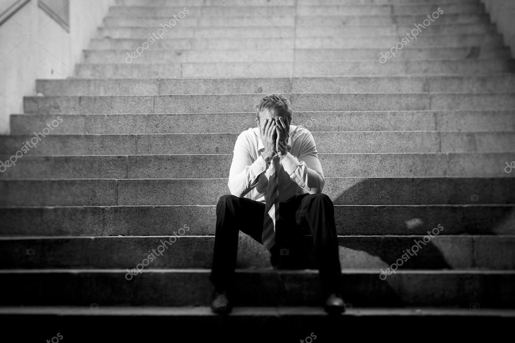 Businessman crying lost in depression sitting on street concrete stairs ...