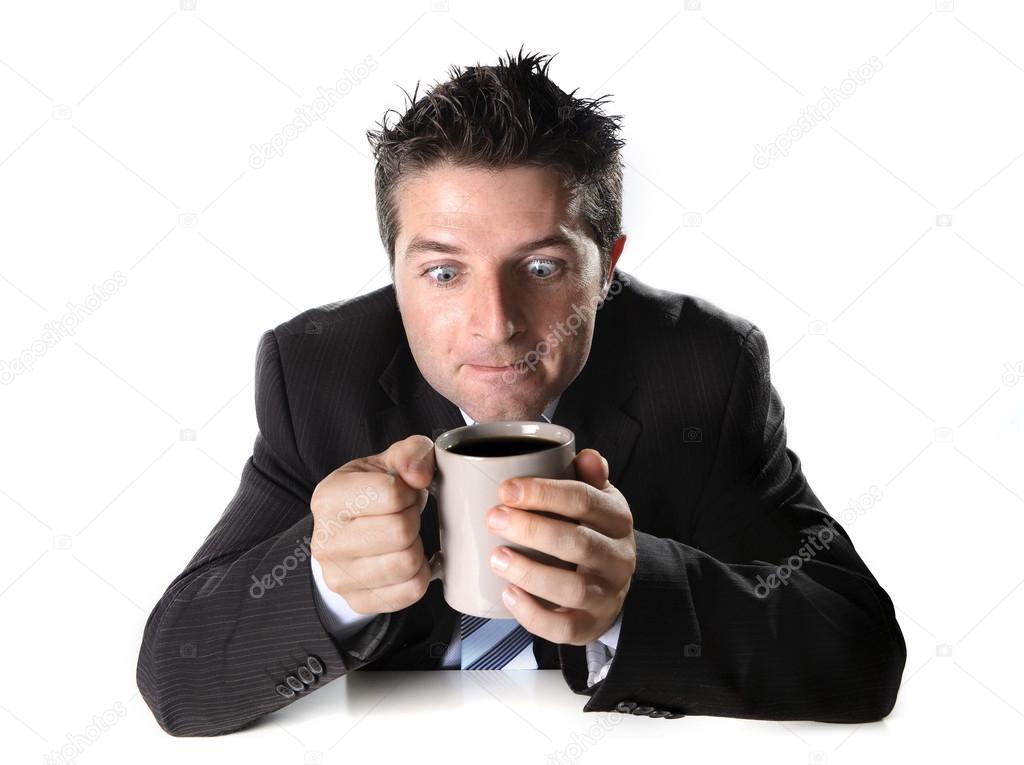 Addict business man in suit and tie holding cup of coffee anxious and ...