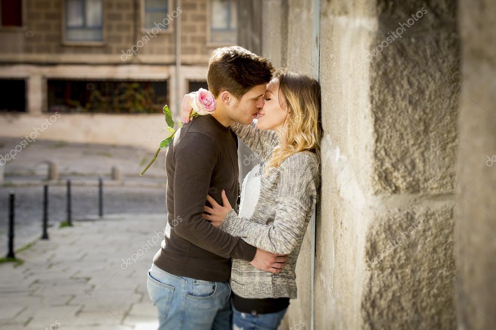Candid Portrait Of Beautiful European Couple With Rose In Love Kissing