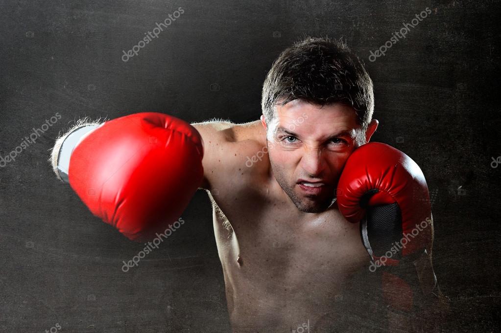 Aggressive boxer man boxing in fighting gloves throwing angry right ...