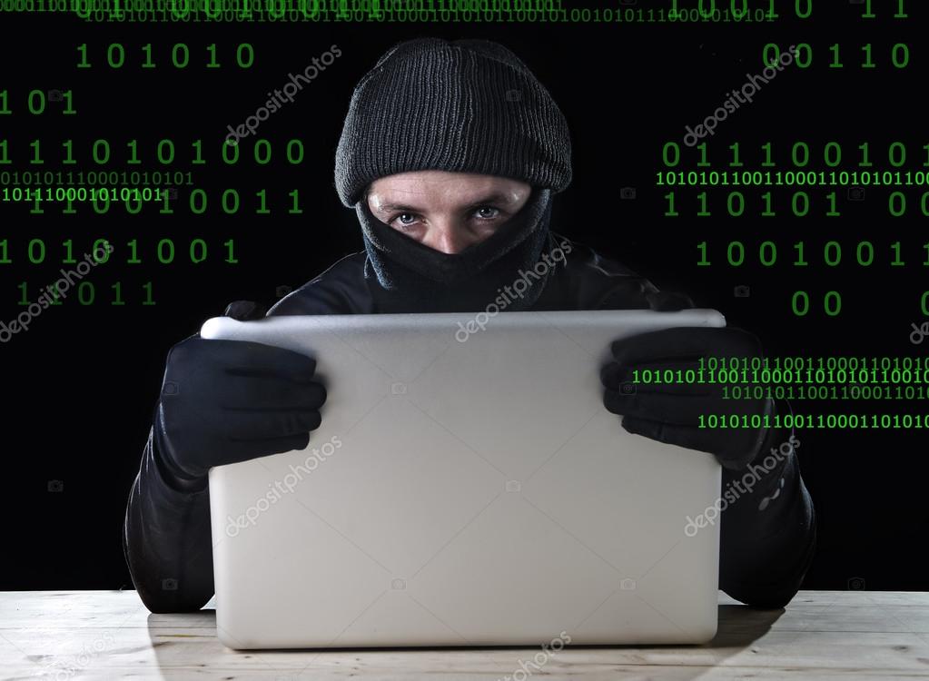 Hacker man in black using computer laptop for criminal activity hacking ...