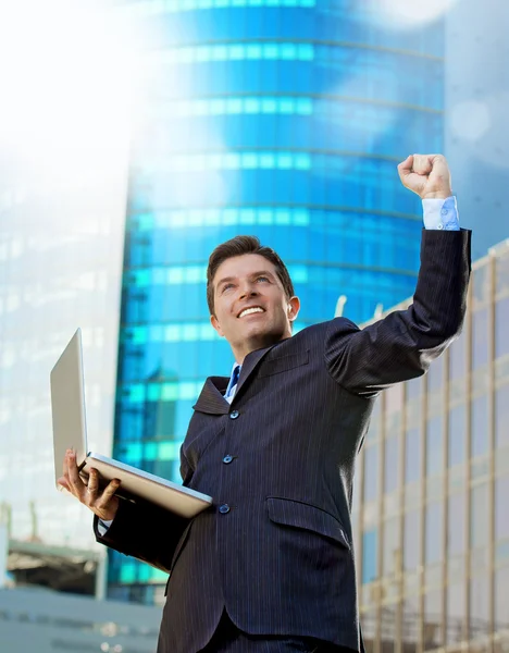 Successful businessman with computer laptop happy doing victory ...