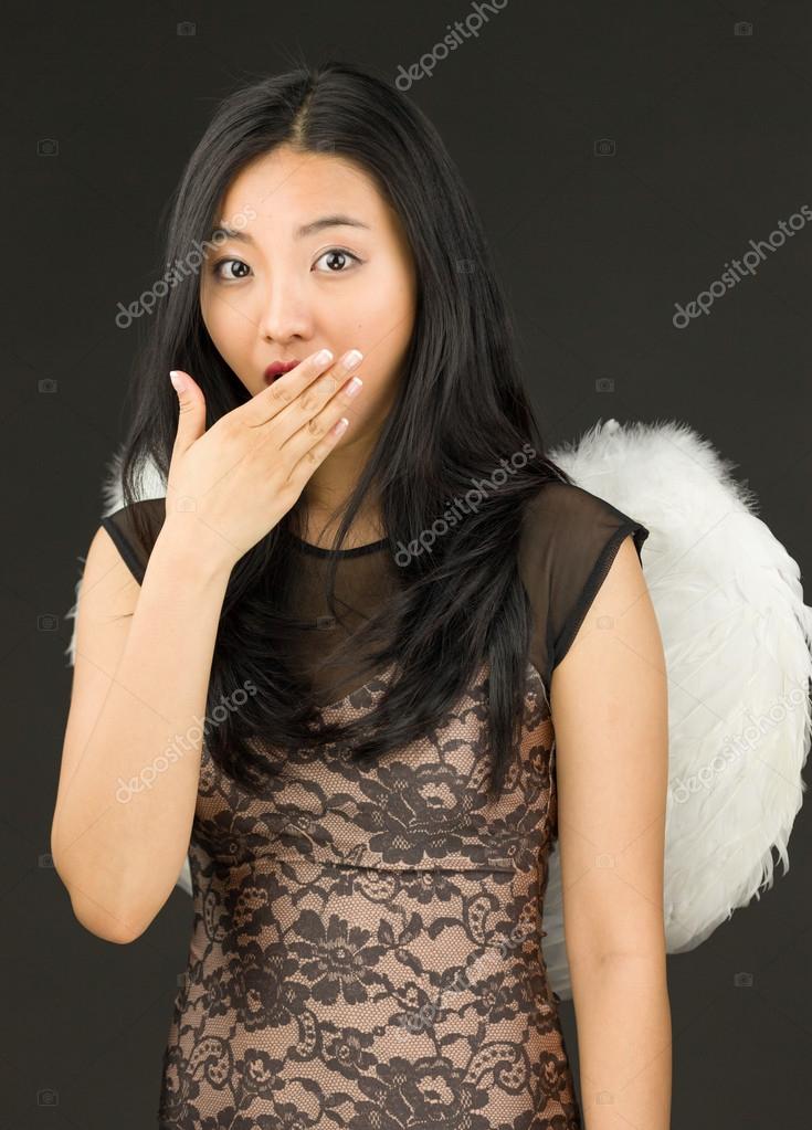 Asian young woman dressed up as an angel looking shocked with big eyes — Stock Photo © Bruno135 ...