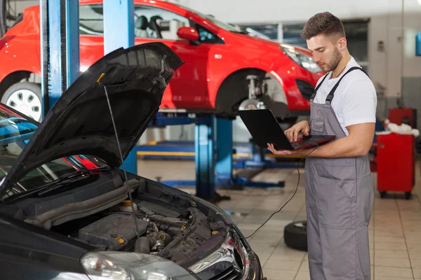 Auto mechanic working on a computer - Stock Image - Everypixel