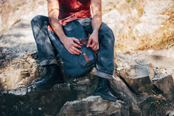 Hiker man opening his backpack - Stock Image - Everypixel