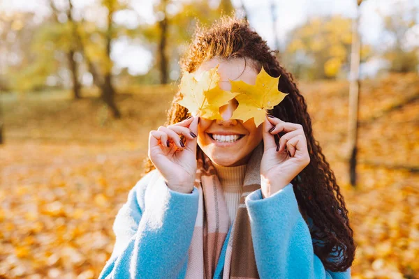 Young beautiful woman have fun with yellow autumn leaves in the park on ...