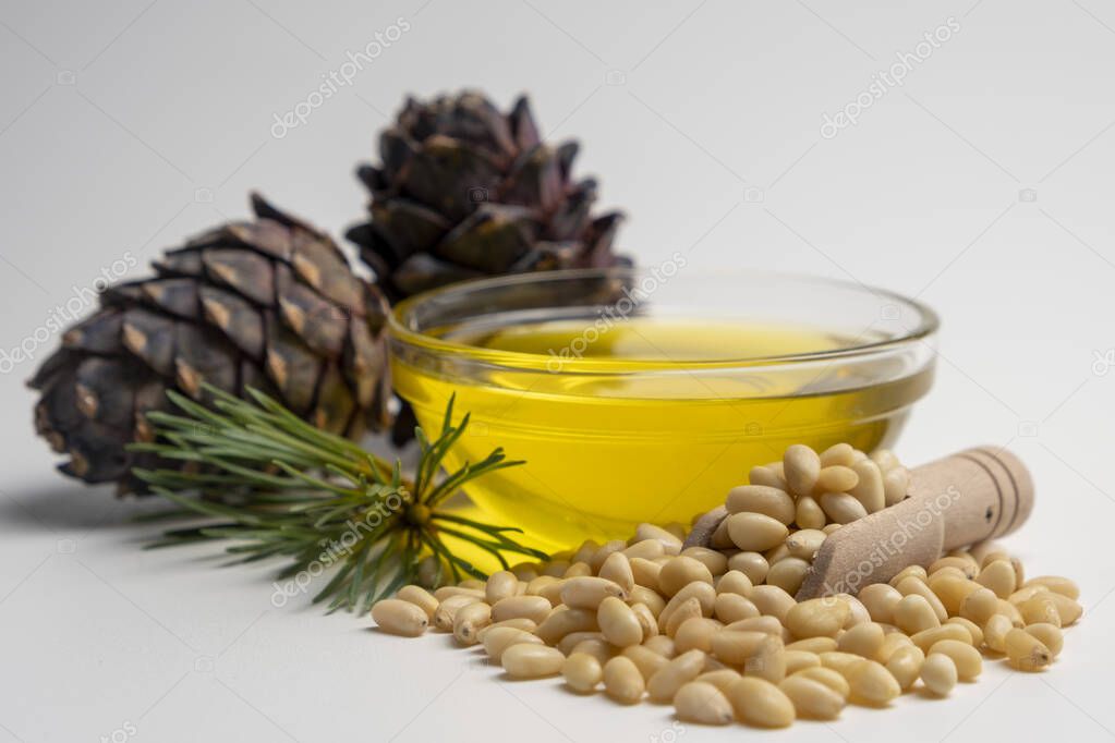 Aceite de piñones con piñones pelados y conos de pino sobre fondo ...
