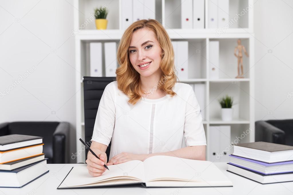 Acclaimed author writing her new book in office with bookcase. Concept ...