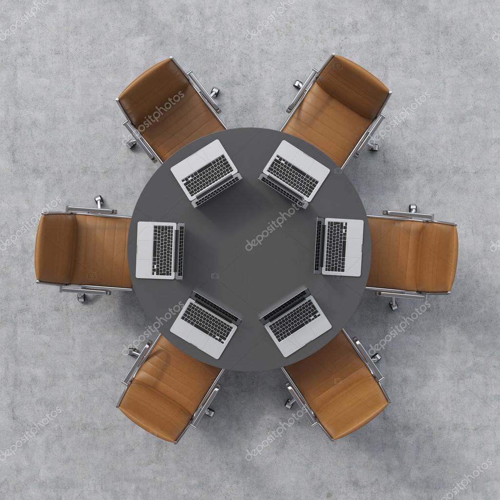Top view of a conference room. A black round table, six brown leather ...