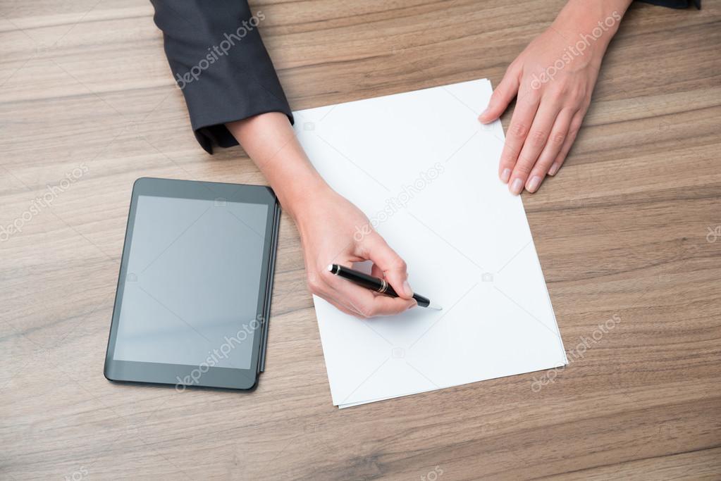Closeup of a business woman's hands while writing down some essential ...