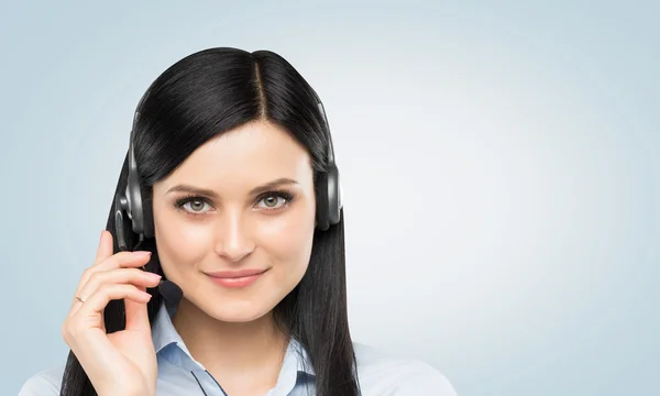 Front view of the smiling brunette support phone operator with headset ...