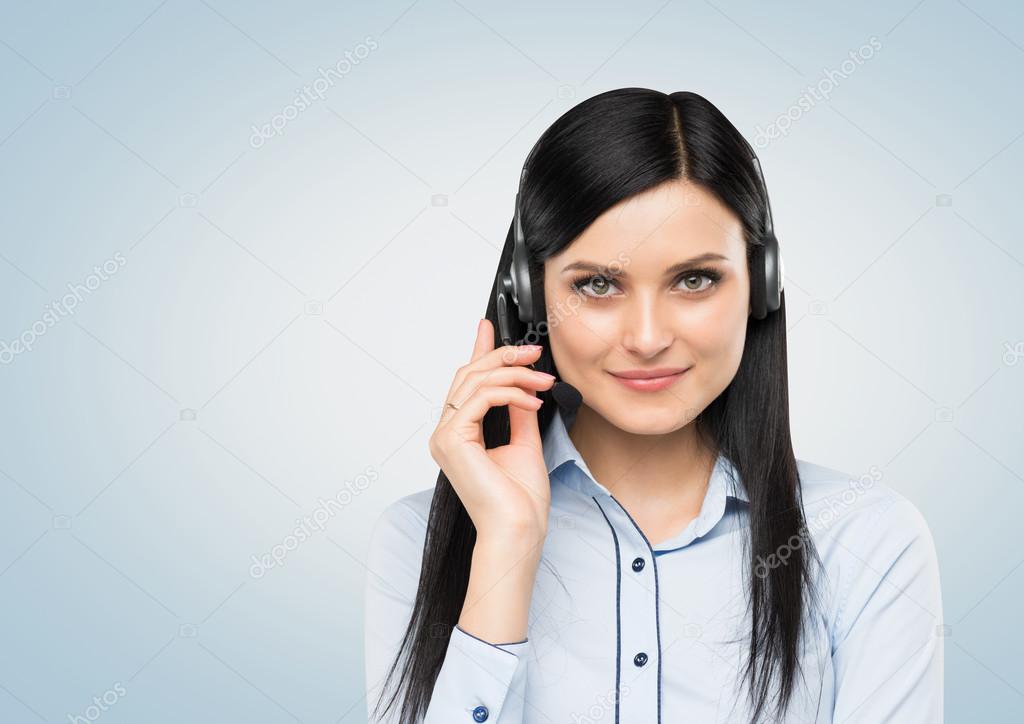 Front view of the smiling brunette support phone operator with headset ...