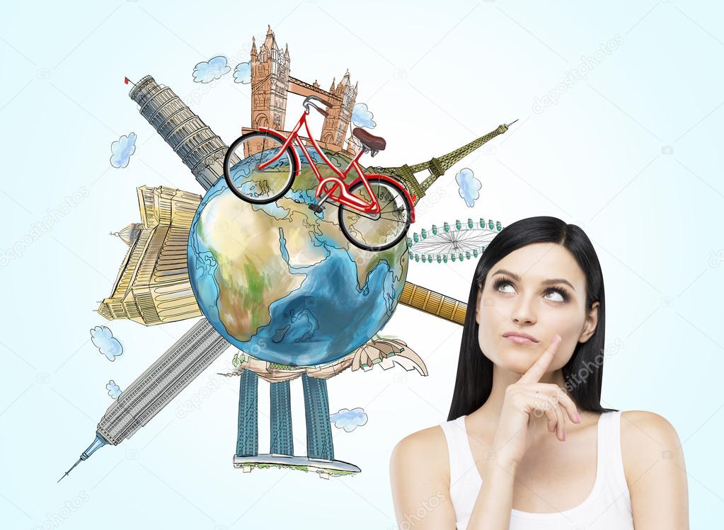 A brunette woman is dreaming about travelling. The globe with the most ...