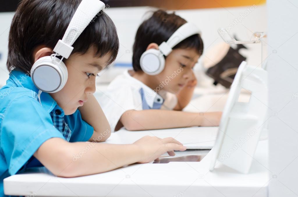 Little boy with headset in classroom Stock Photo by ©wckiw 61309377