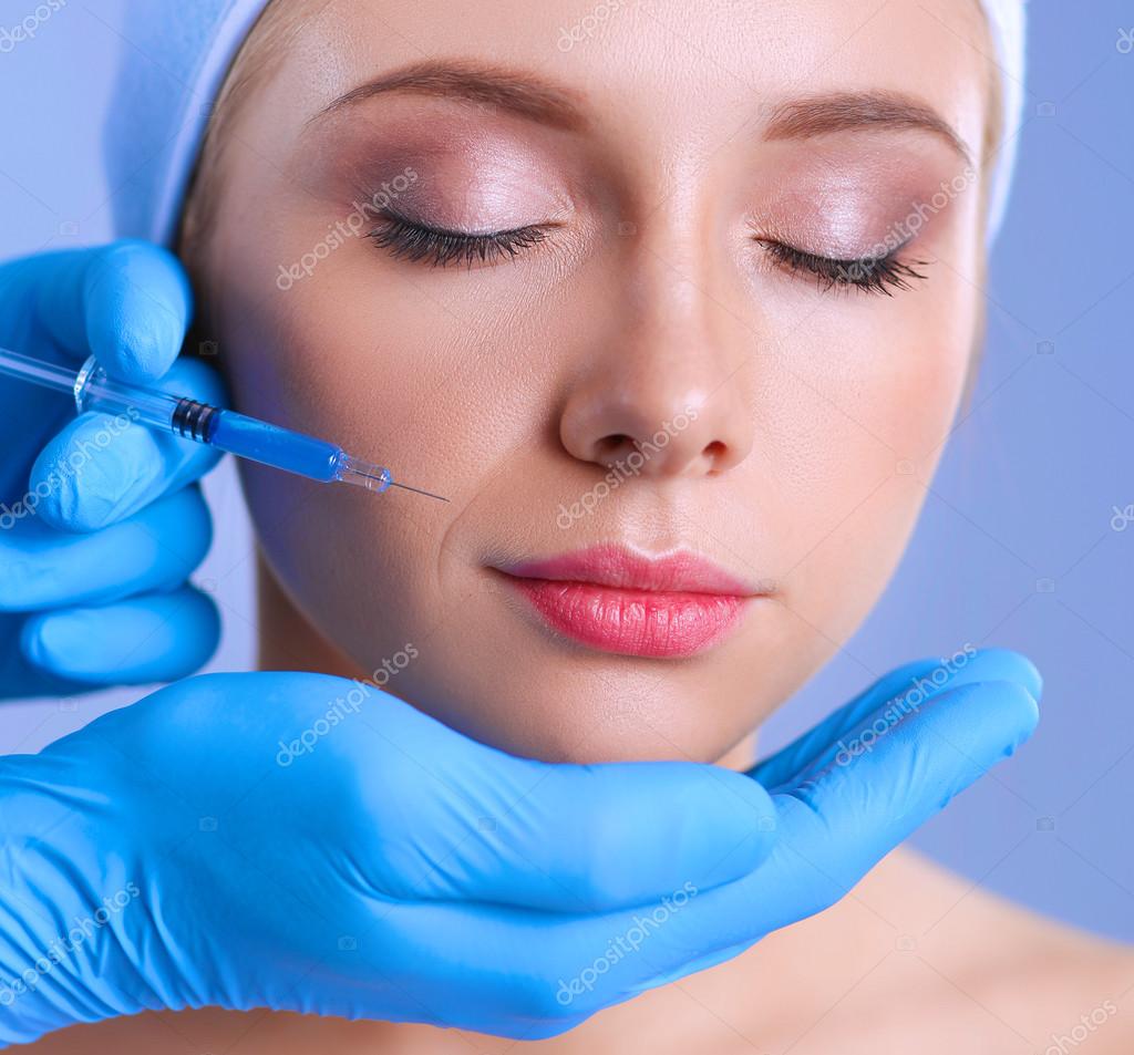 Cosmetic injection on the pretty woman face. Isolated on gray ...