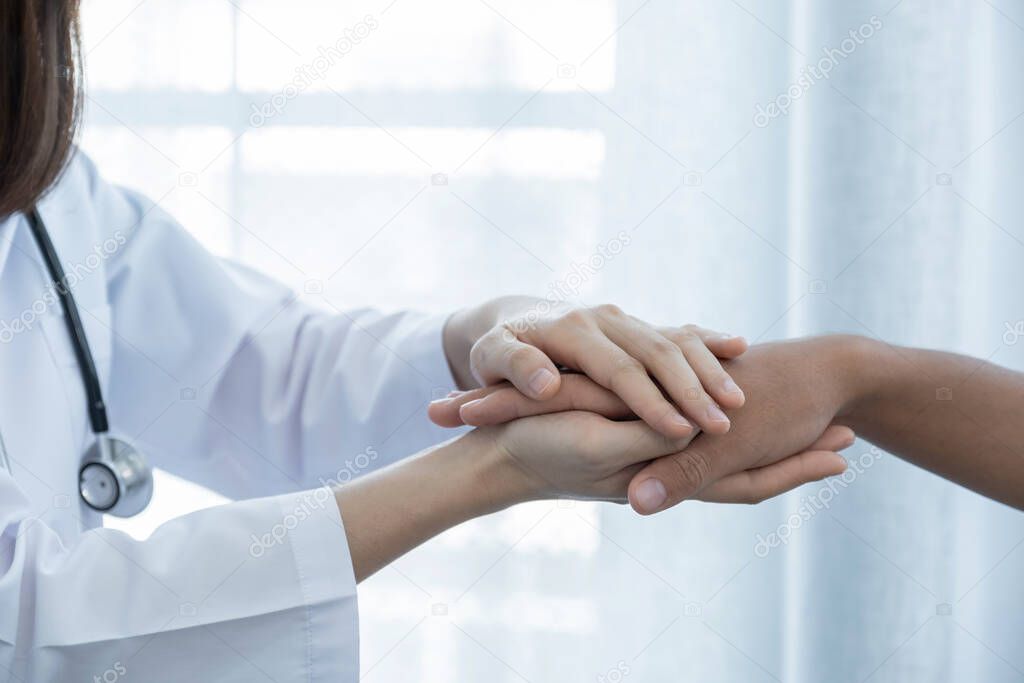 Las manos del médico sosteniendo la mano del paciente para animar y explicó los resultados del ...