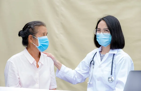 The female doctor supports the patient's shoulder, the elderly and ...