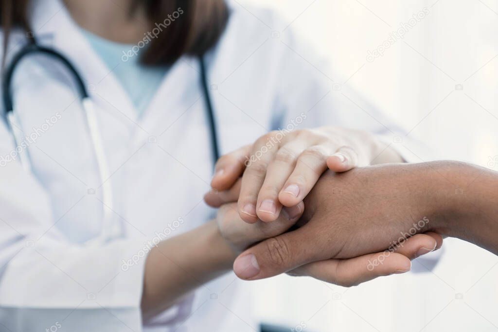 Las manos del médico sosteniendo la mano del paciente para animar y ...