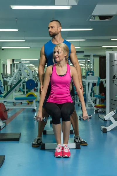 Young couple at a joint training session in the gym. Mutual assistance ...