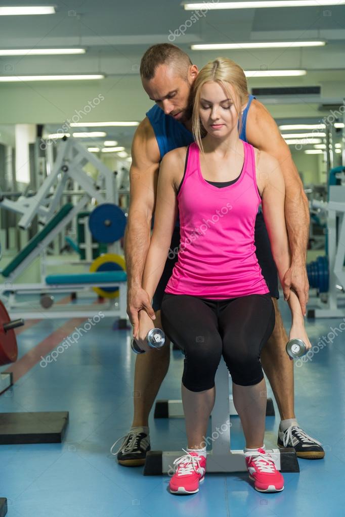 Young couple at a joint training session in the gym. Mutual assistance ...